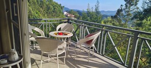 Varanda com móveis de vime, uma mesa e uma xícara de café.