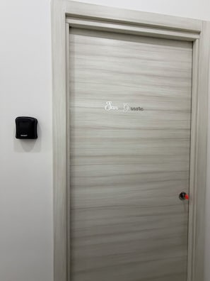 Uma porta com superfície texturizada e placa com o nome 'San Giovanni'.