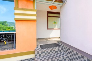 Uma varanda com vista para o verde, uma janela com um logotipo e um chão de azulejos.