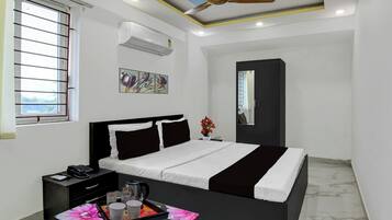 Quarto moderno com cama, mesa de cabeceira e ventoinha no teto.