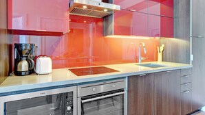 Uma cozinha moderna com fogão embutido, forno e eletrodomésticos de aço inoxidável.