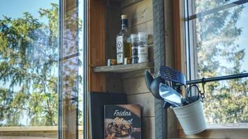 Uma área de cozinha com uma estante de madeira com utensílios e condimentos.