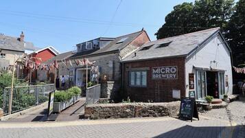 Um edifício de tijolos com uma placa indicando 'MICRO BREWERY' e uma placa de informação para 'LYME REGIS' na frente.