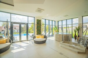 Amplo espaço interno com piscina, assentos e vista para o exterior.