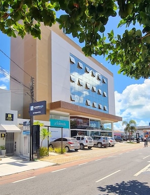 Um edifício de vários andares com design arquitetônico moderno, destacando uma fachada de vidro e uma placa com a inscrição 'LaundryHome'.