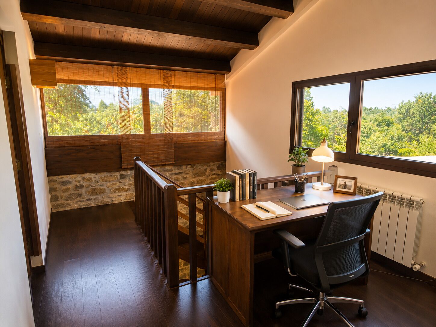 Quarto com escrivaninha, cadeira, livros, abajur e vista para árvores pela janela.
