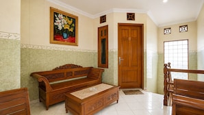 A room with a wooden bench, a sofa, a door, and a window.