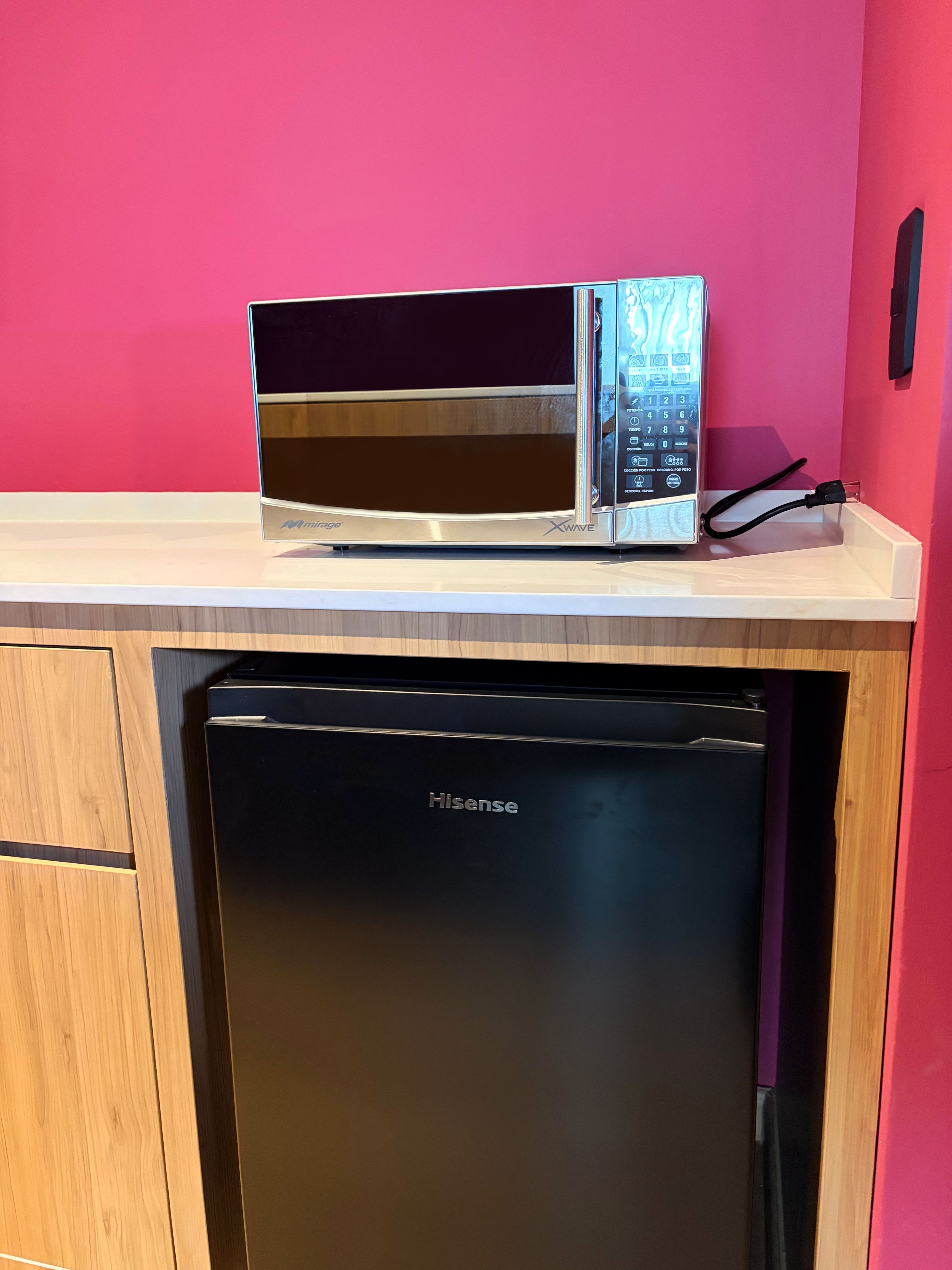 Forno de micro-ondas em bancada, com uma lava-louças Hisense logo abaixo.