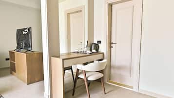 Quarto com escrivaninha, cadeira e porta.