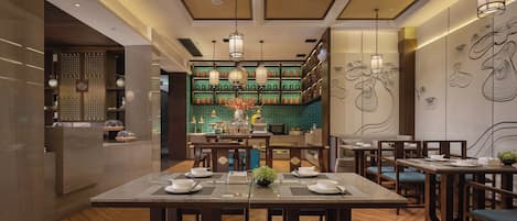 Um restaurante com uma mesa central, cadeiras e um espaço de bar com prateleiras.