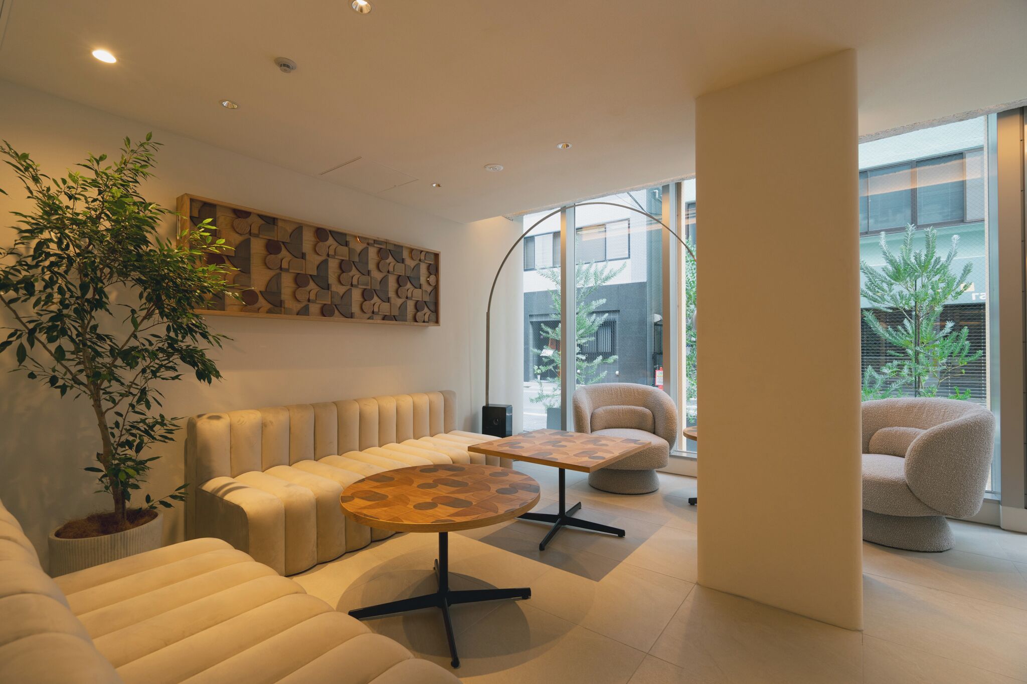 Uma sala de estar moderna com sofá, mesa de centro e uma poltrona. Há uma janela grande que oferece vista para o exterior.