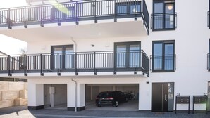 Um edifício residencial com vários andares, garagem, varandas e caixas de correio.