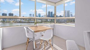 Quarto com vista para a cidade, uma mesa e duas cadeiras.