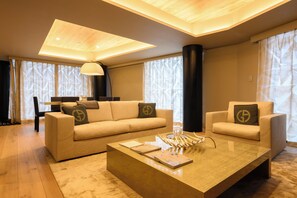 Uma sala de estar moderna com sofá, poltronas, mesa de centro e abajur.