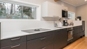 Cozinha moderna com uma janela ampla, eletrodomésticos embutidos e design minimalista.
