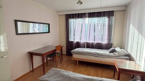 Um quarto com cama, escrivaninha e cadeira.