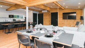 Um interior moderno com área de jantar, cozinha e espaço para sentar.
