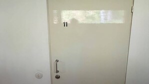 Uma porta branca com o número 11 e uma maçaneta.