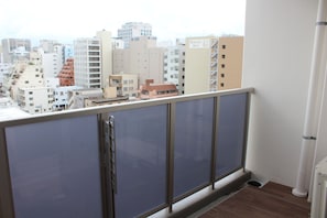 Uma varanda com vista para a paisagem urbana, incluindo vários edifícios e um céu claro.