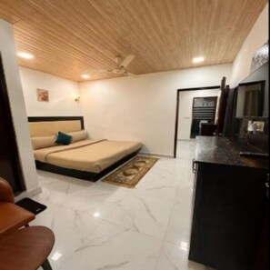 Quarto com cama, escrivaninha e ventilador de teto.