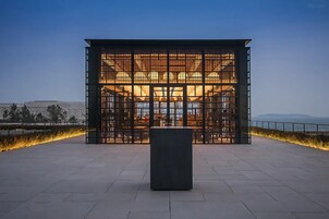 Um edifício moderno com fachada de vidro e um pátio central.