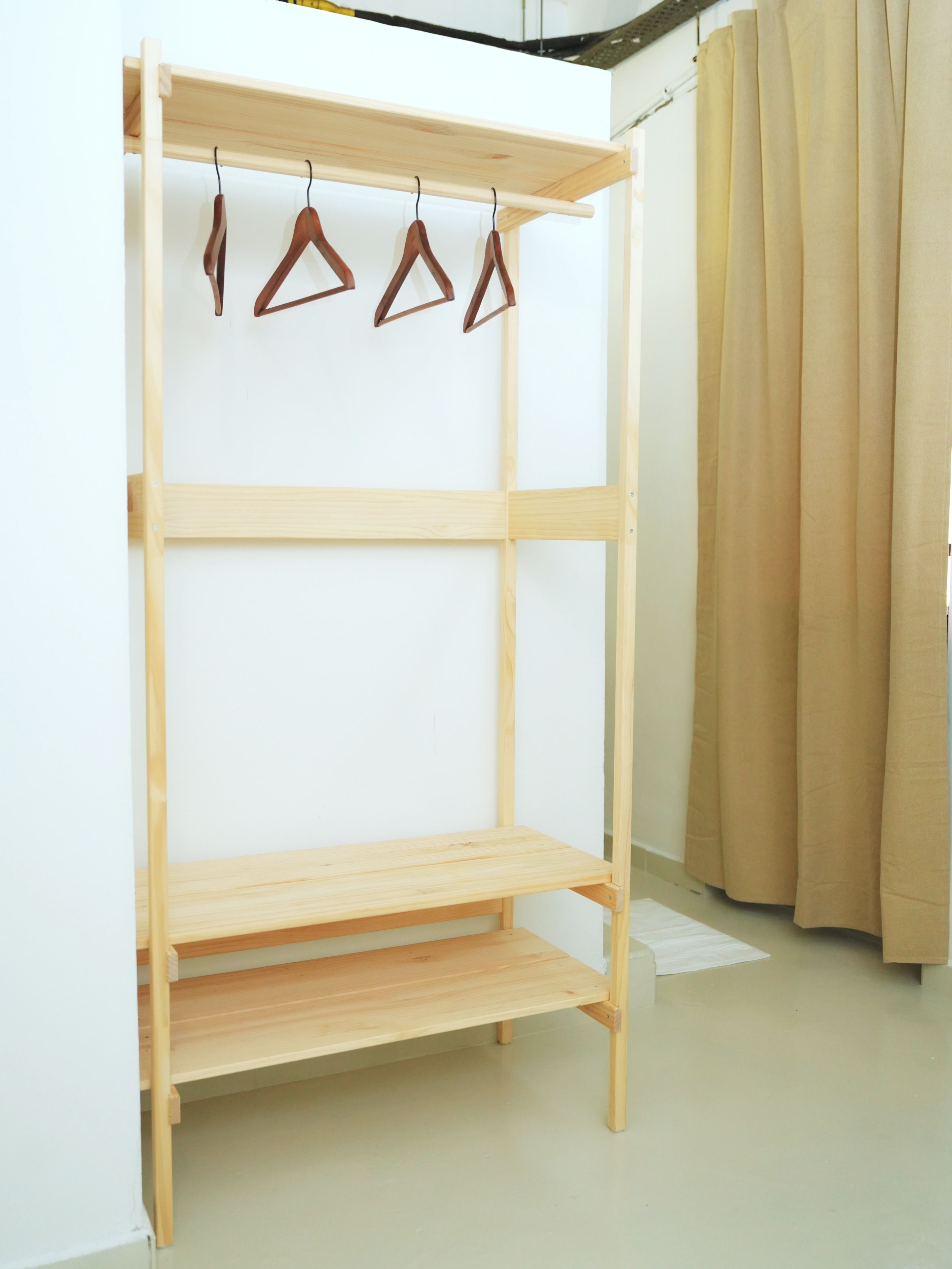 Guarda-roupa de madeira com três prateleiras e barra para pendurar roupas.