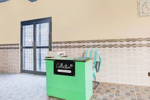 Um quarto com um balcão verde identificado como 'Collection' e uma porta com janela.