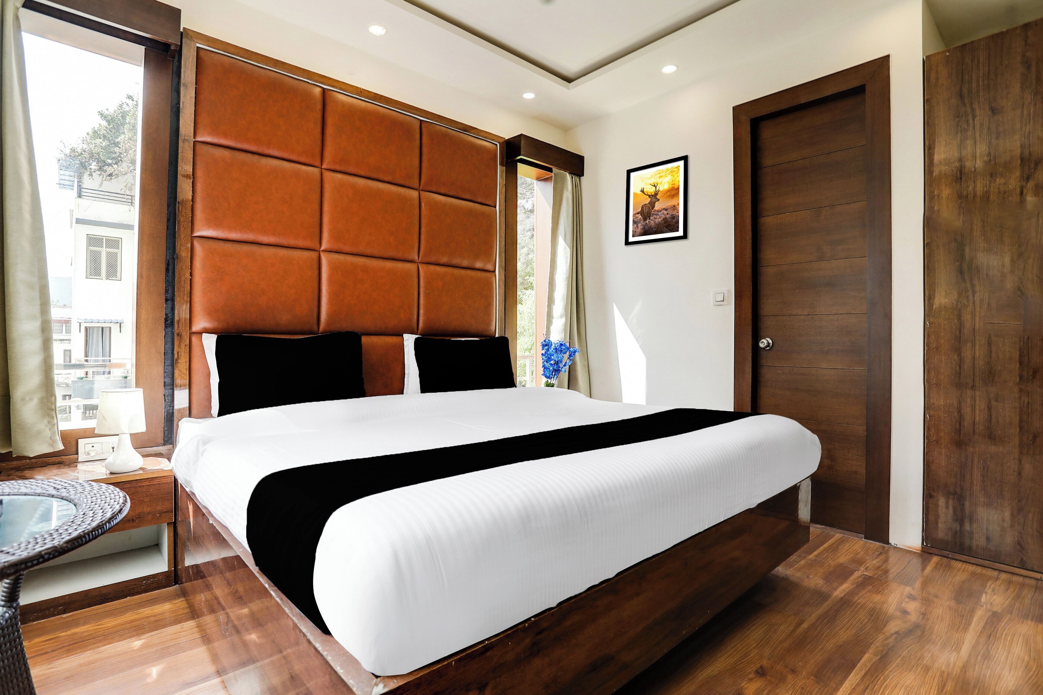 Um quarto com uma cama grande, cabeceira de madeira e uma porta.