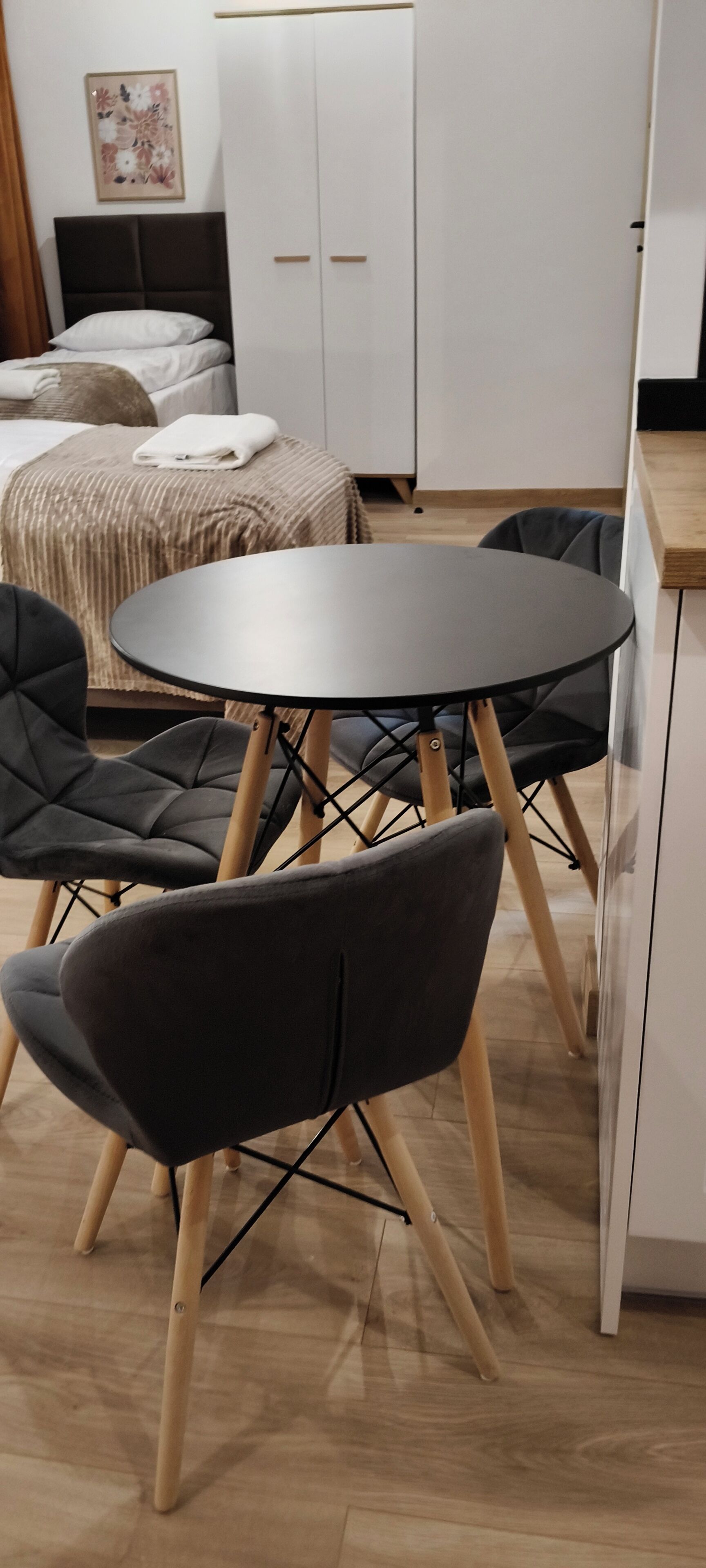 Quarto moderno com cama, mesa de cabeceira e guarda-roupa.