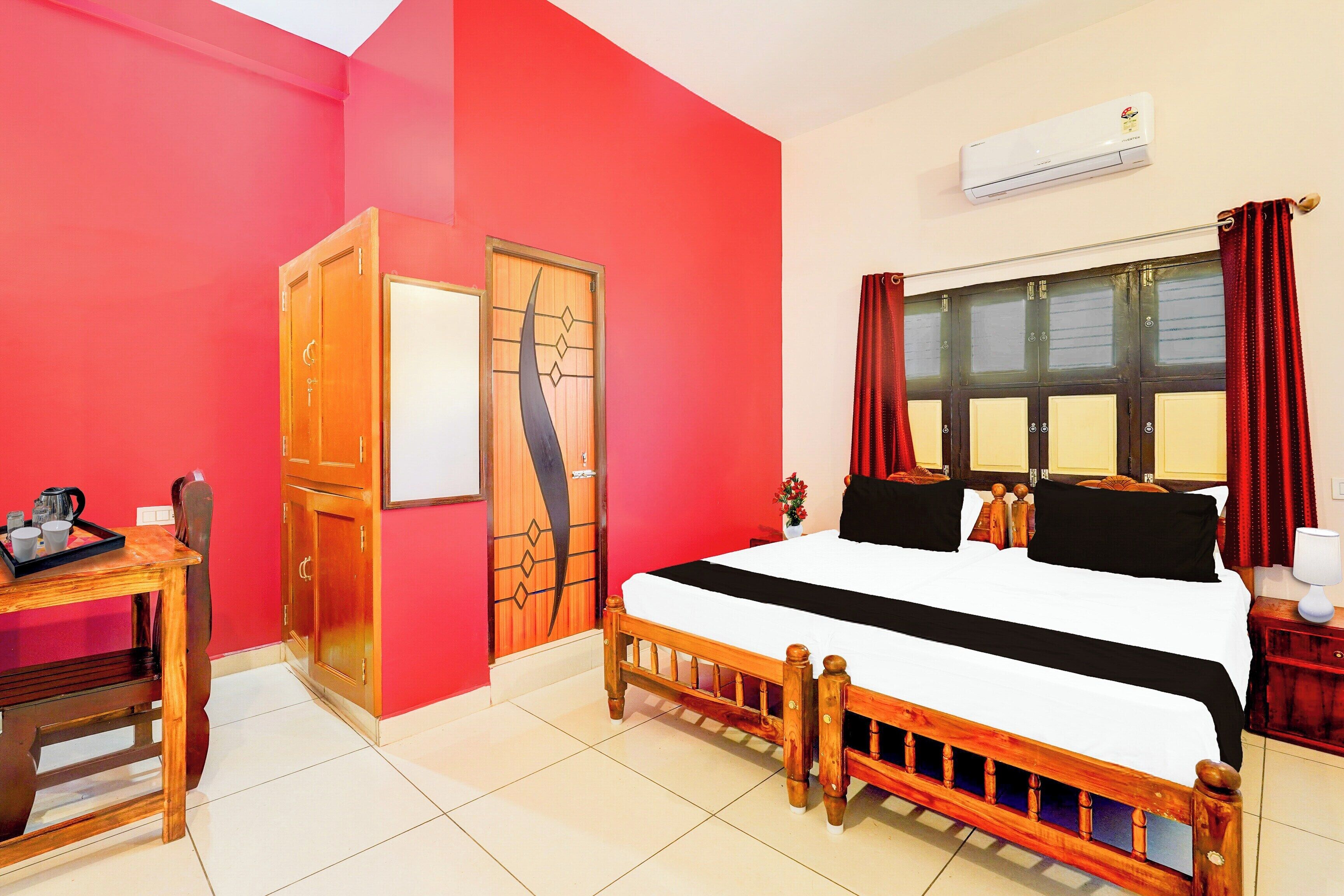 Quarto de hotel com cama, escrivaninha e guarda-roupa.