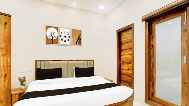 Quarto com cama, cabeceira de madeira e uma grande porta de correr.