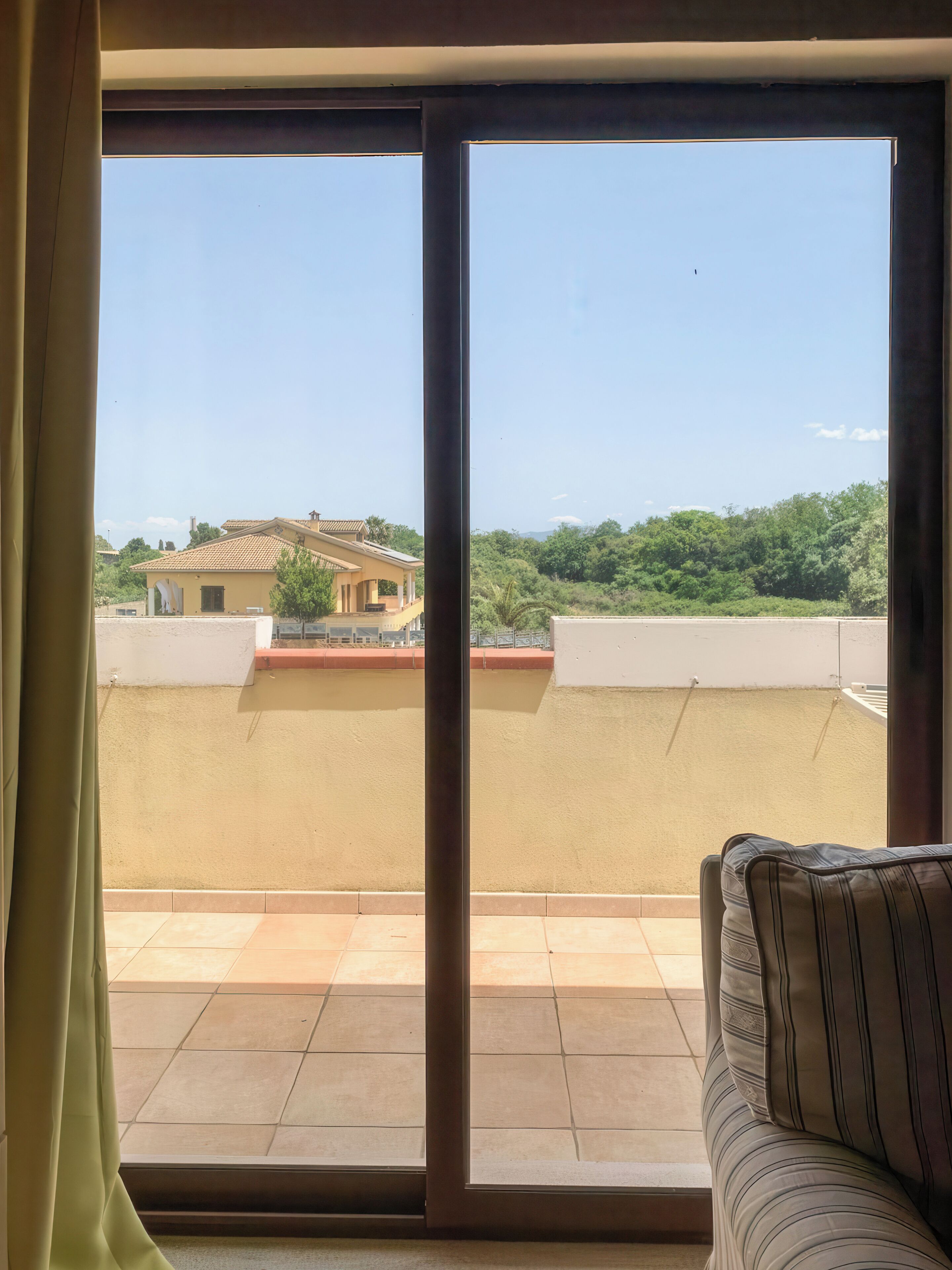Uma varanda com vista para um edifício e árvores.