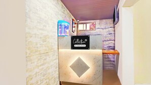 Uma receção com design em mármore, uma placa de serviço da empresa e um aquário em cima.