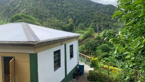 Um edifício com telhado de chapa metálica, uma porta e janelas.