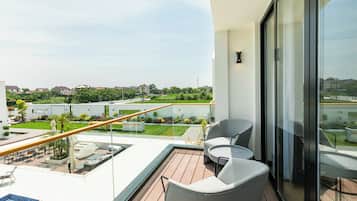 Varanda moderna com piscina, área de estar externa e vista para uma área residencial.