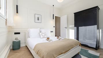 Quarto com cama, mesas de cabeceira, guarda-roupa e um quadro na parede.