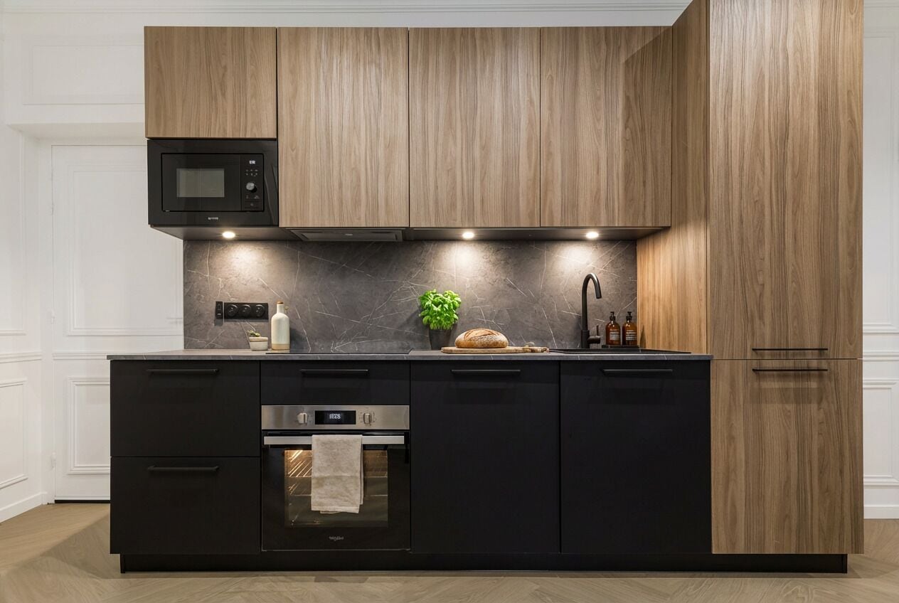 Uma cozinha moderna com micro-ondas, forno e pia embutidos.