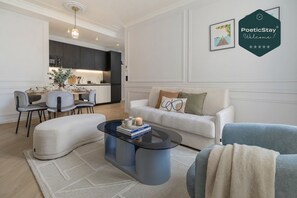 Uma sala de estar moderna com um sofá, uma mesa de centro de vidro e um espaço de jantar com cadeiras e uma mesa.