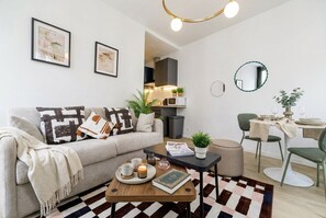 Uma sala de estar moderna com sofá, mesa de centro e área de refeições.