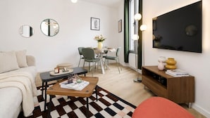 Uma sala de estar moderna com sofá, mesa de centro e área de jantar com cadeiras e mesa.