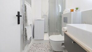 A modern bathroom with a shower, toilet, and a bathtub.