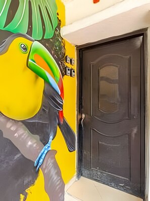 Uma porta com acabamento escuro e uma parede com um mural colorido.