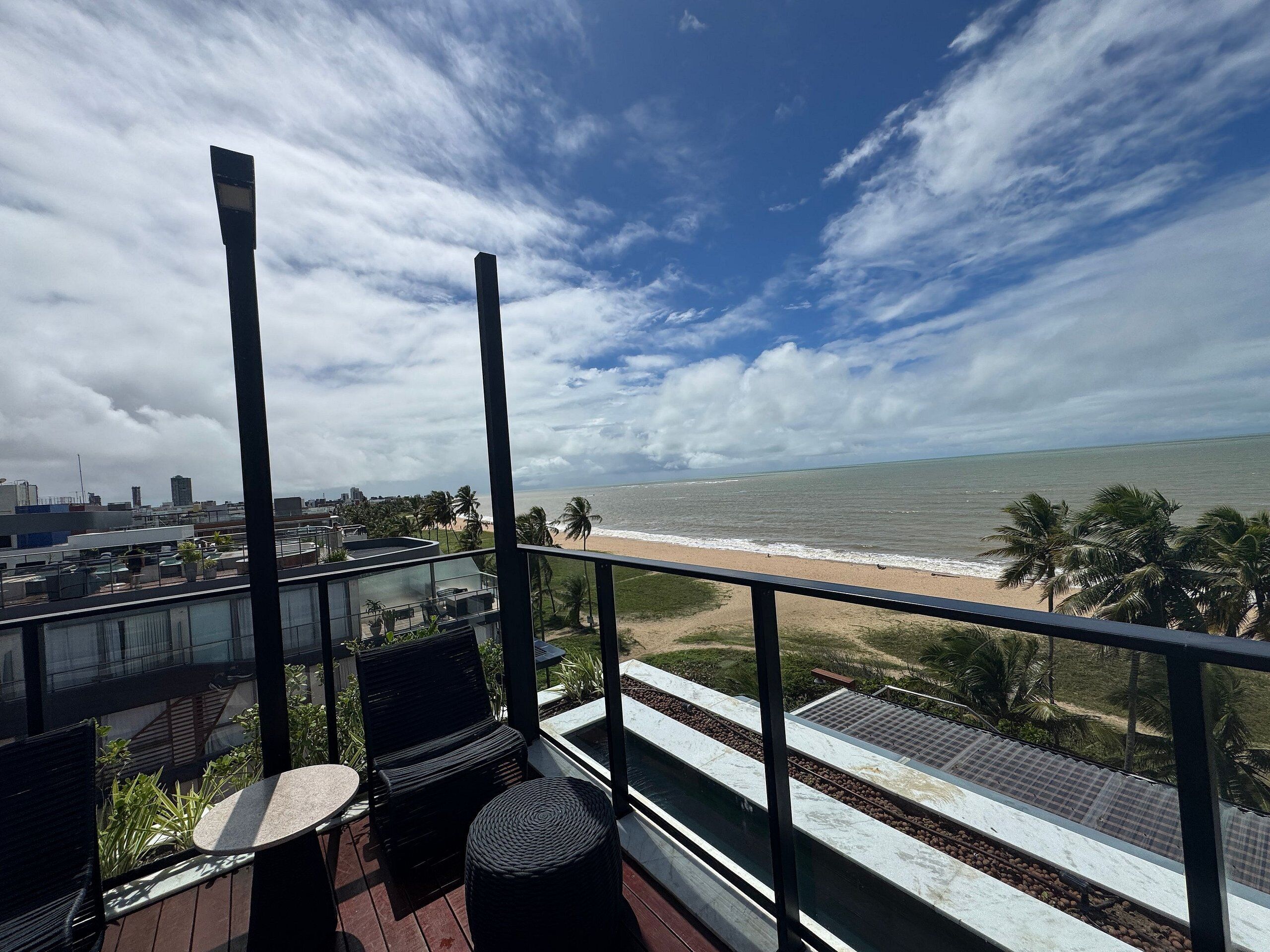Uma varanda com vista para a praia e o horizonte da cidade.