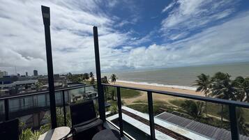 Uma varanda com vista para a praia e o horizonte da cidade.