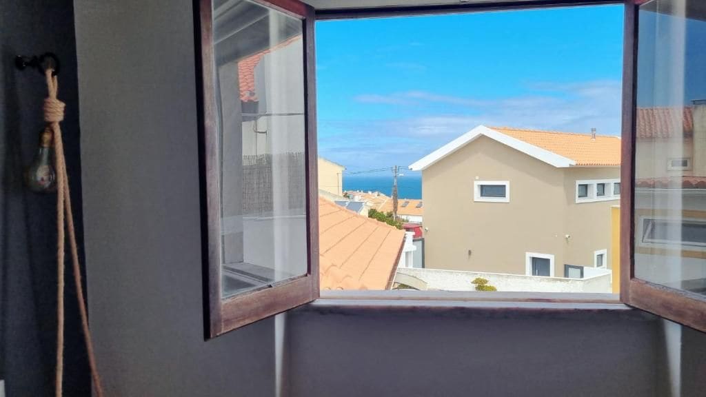 Janela com vista para um edifício e céu limpo.