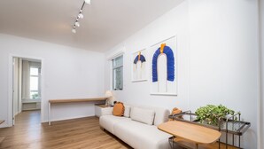 Uma sala de estar moderna com um sofá, uma mesa de madeira e uma planta.