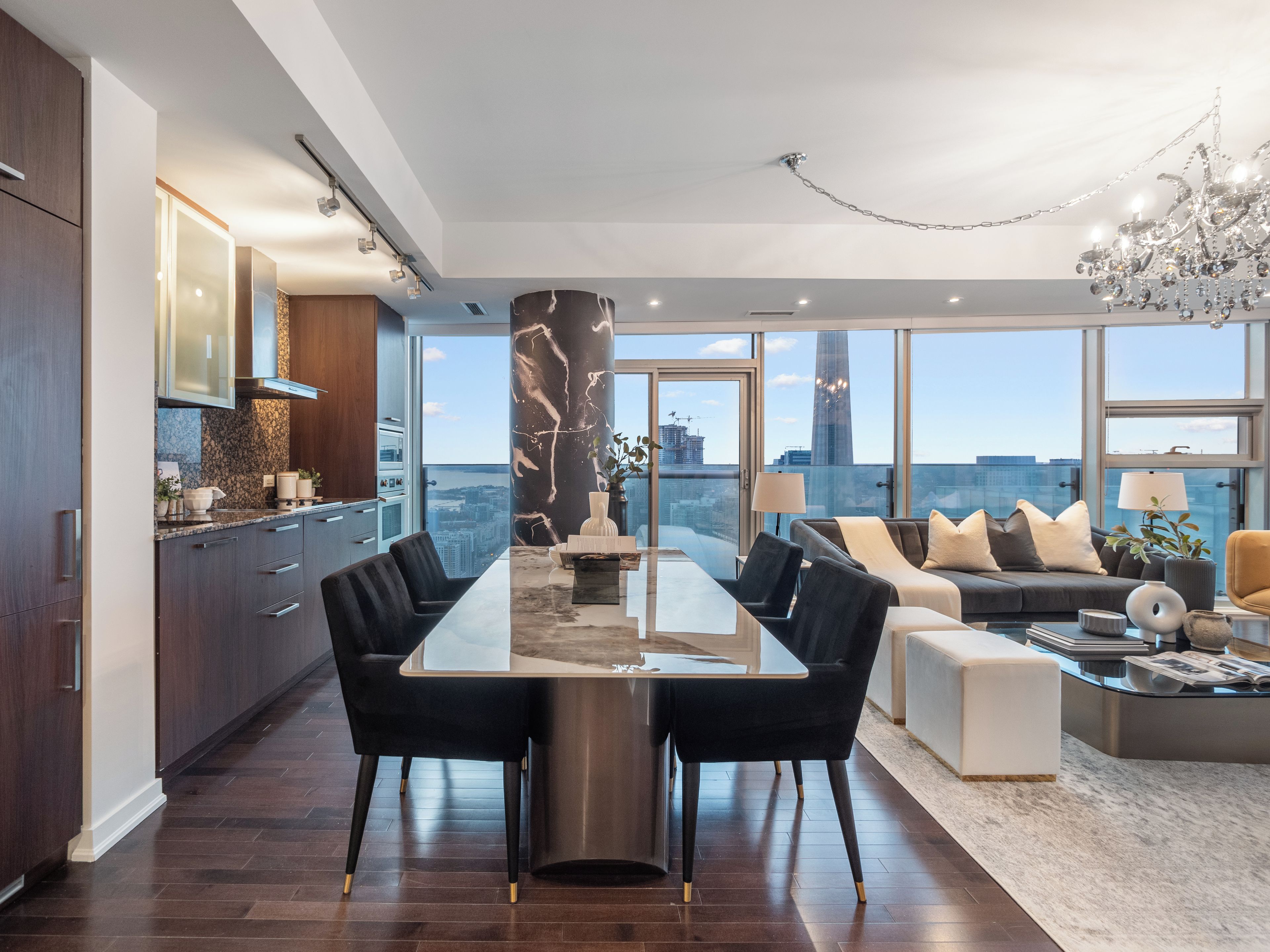 Interior moderno com sala de jantar, cozinha e área de estar com vista para a cidade.