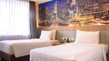 Quarto de hotel com duas camas, vista para a cidade e um telefone na mesa de cabeceira.