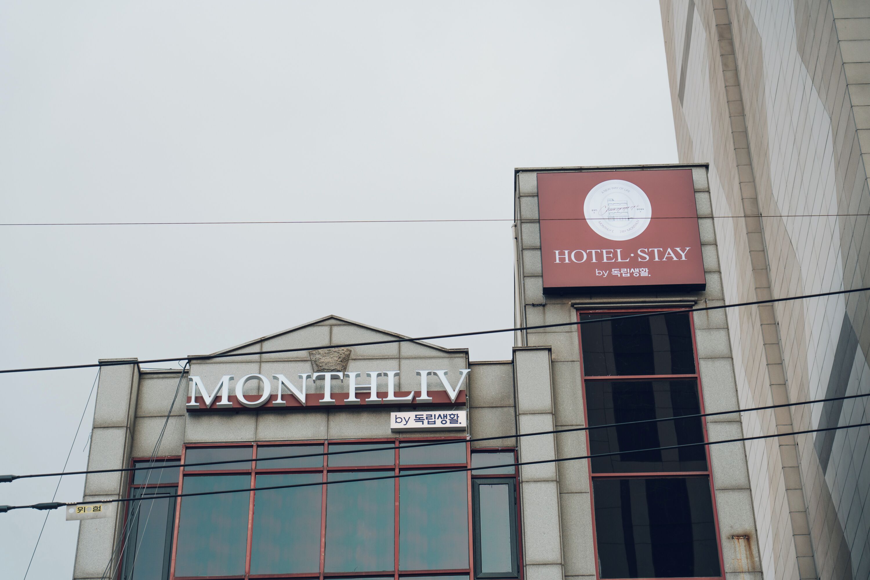 Um edifício com uma placa que diz 'MONTHLIV by 토림하월'.
