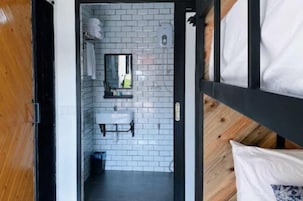 Casa de banho com lavatório branco, espelho e porta-toalhas.